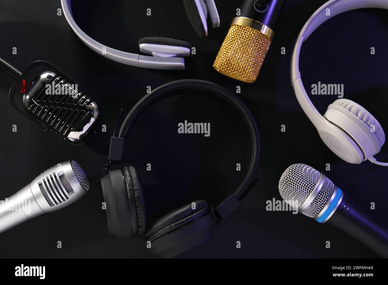 Different microphones and headphones on dark background, flat lay ...