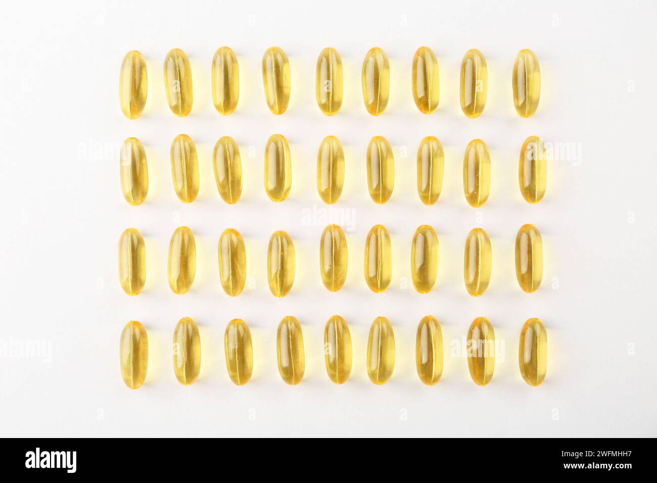 Yellow vitamin capsules on white background, flat lay Stock Photo - Alamy