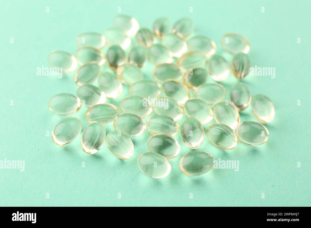 Many vitamin capsules on turquoise background, closeup Stock Photo - Alamy