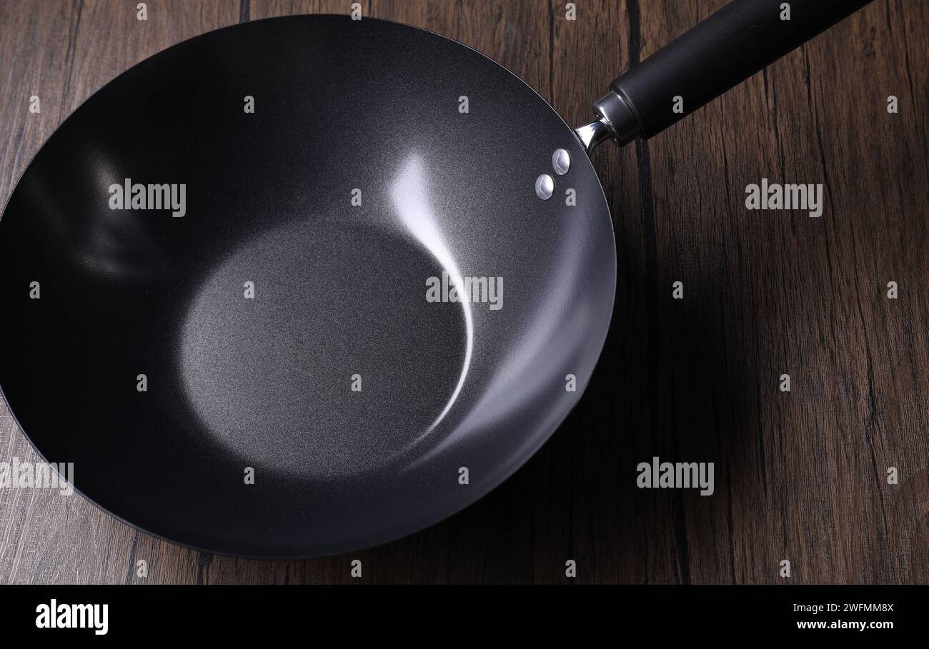 Empty iron wok on wooden table, closeup. Chinese cookware Stock Photo ...