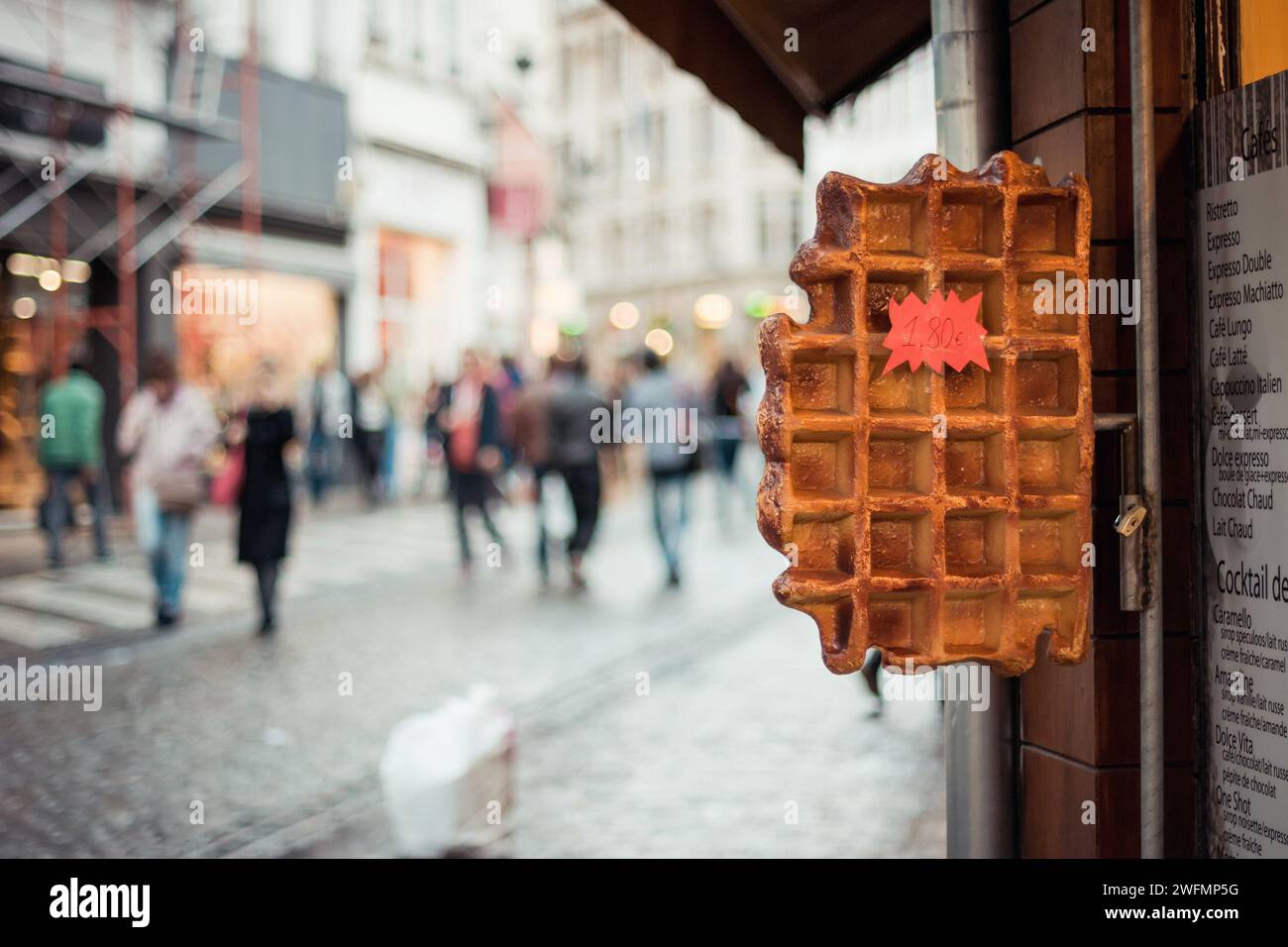 big waffle on the bakery door in Brussels. Blurred background with ...
