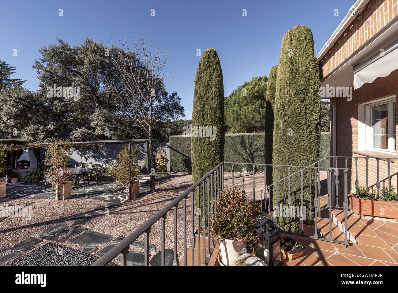 Exterior porch of a single-family home with metal railing, terracotta ...