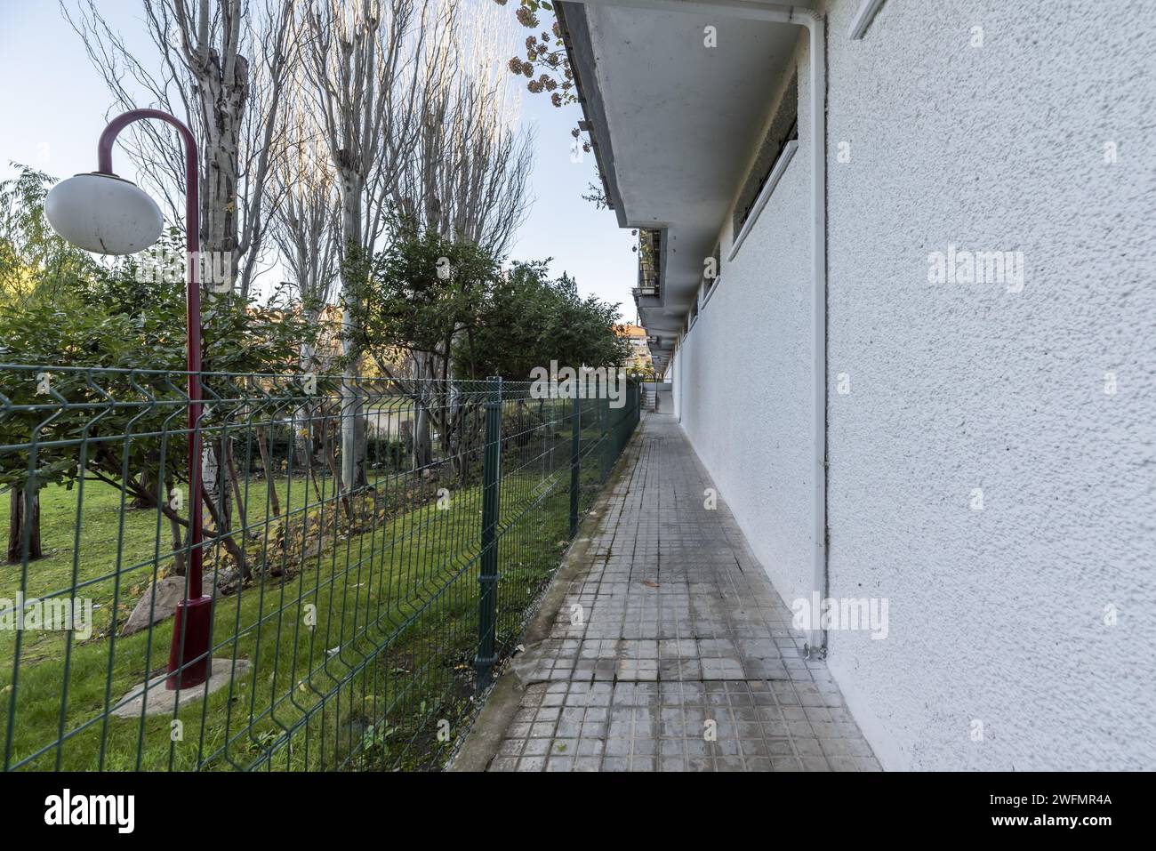 Exterior perimeter corridor with metal fence around a residential ...