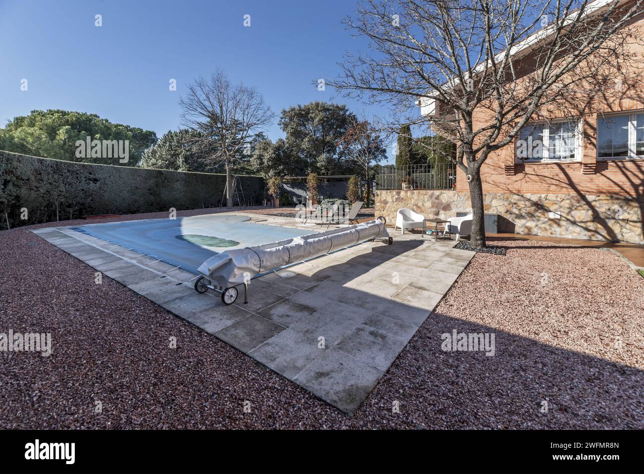 A swimming pool within a plot with a large awning covering the pool ...