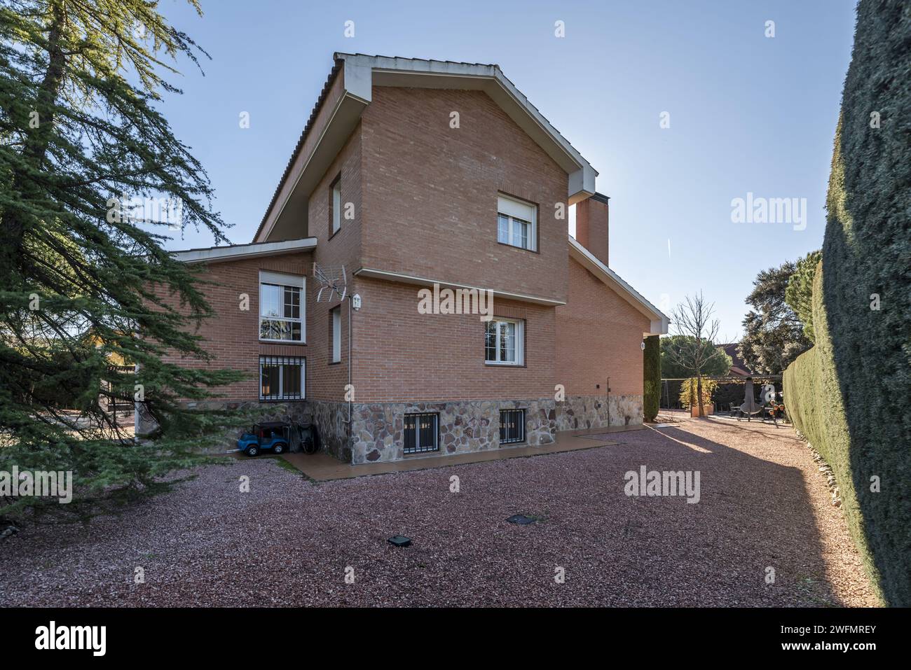 Detached house with two floors with a basement and a thick hedge on the ...