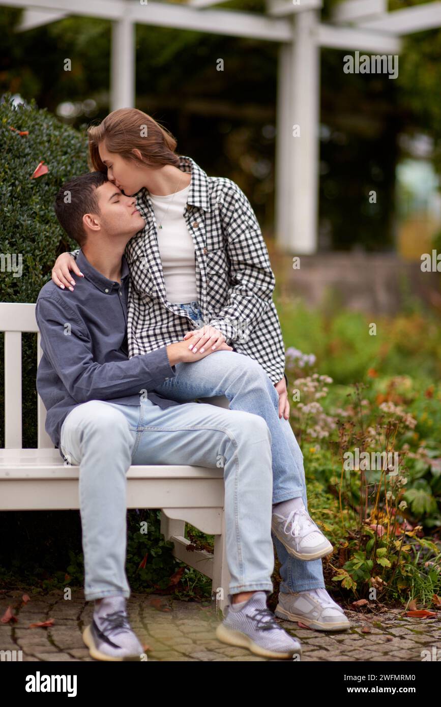 Autumn Romance: Young Couple Embracing and Kissing on Park Bench. Young ...