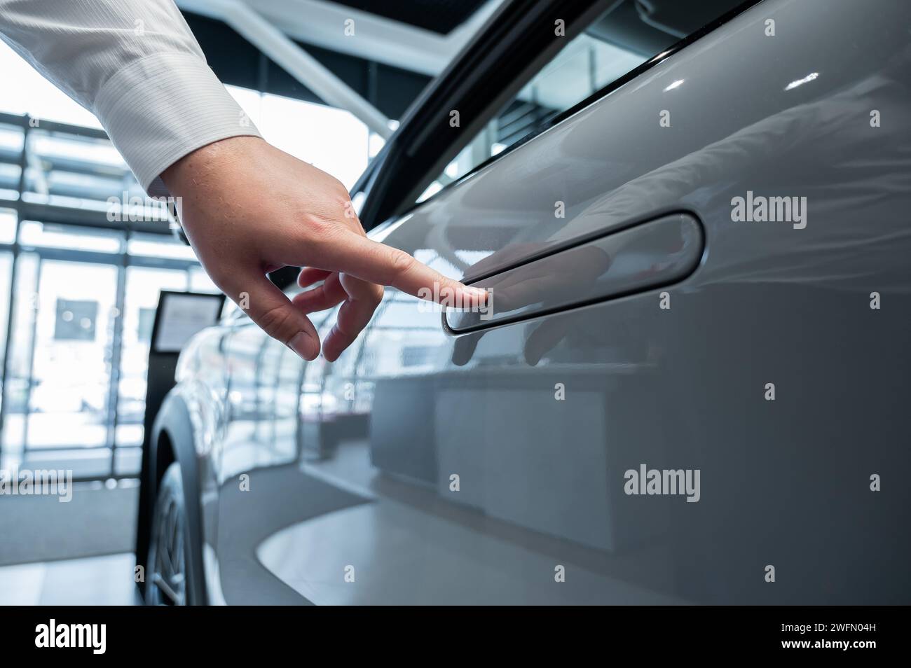 A man opens a car door with a fingerprint. Integrated handle Stock ...