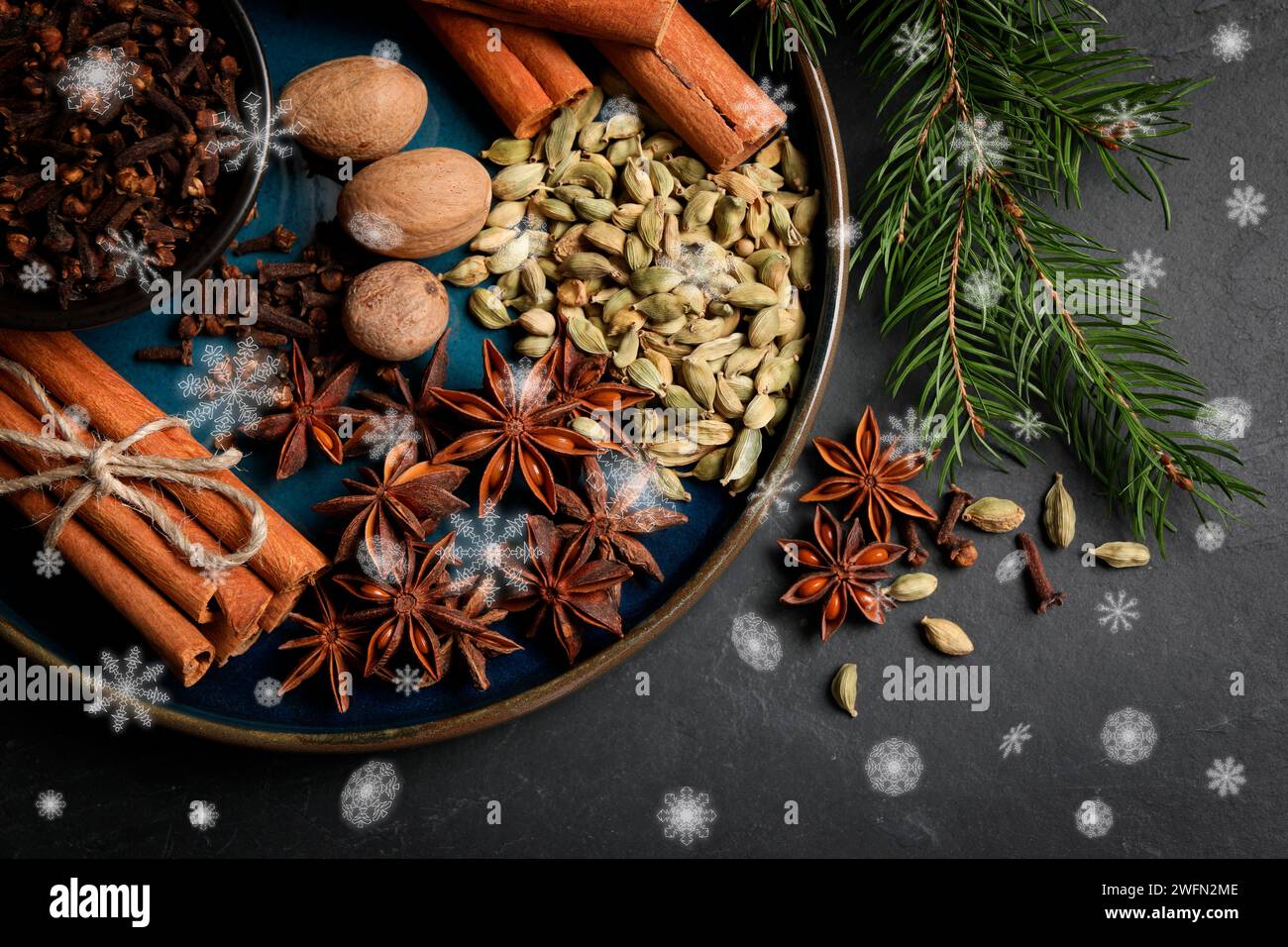 Different spices and fir tree branches on black background, top view ...
