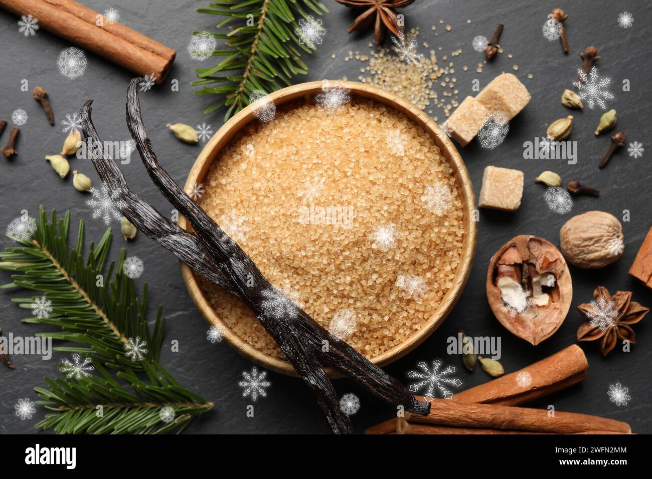 Different spices and fir tree branches on black table, flat lay. Brown ...