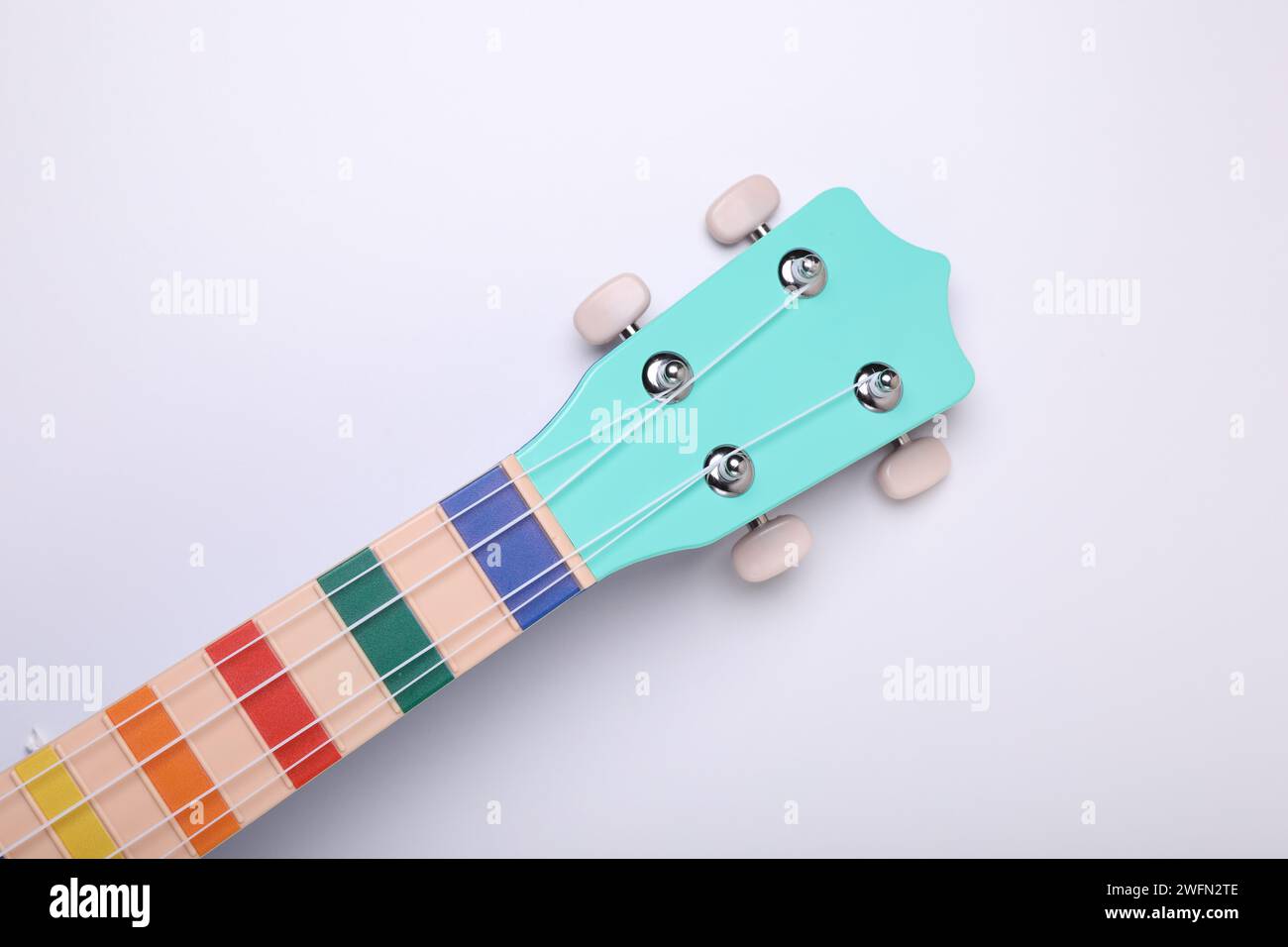 Colorful ukulele neck on white background, top view. String musical ...
