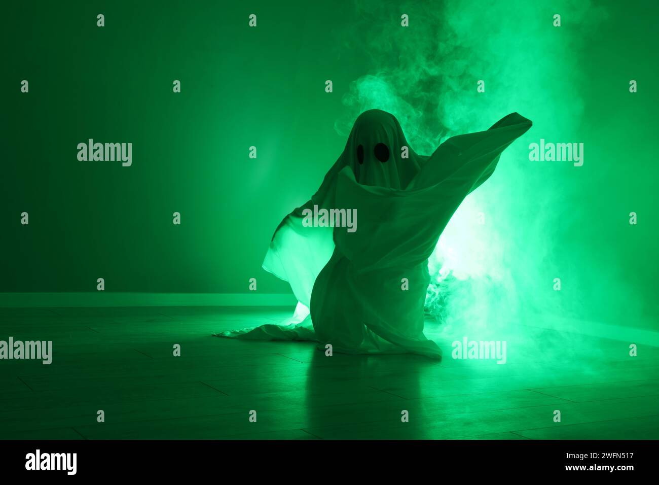 Creepy ghost. Woman covered with sheet in green light Stock Photo - Alamy