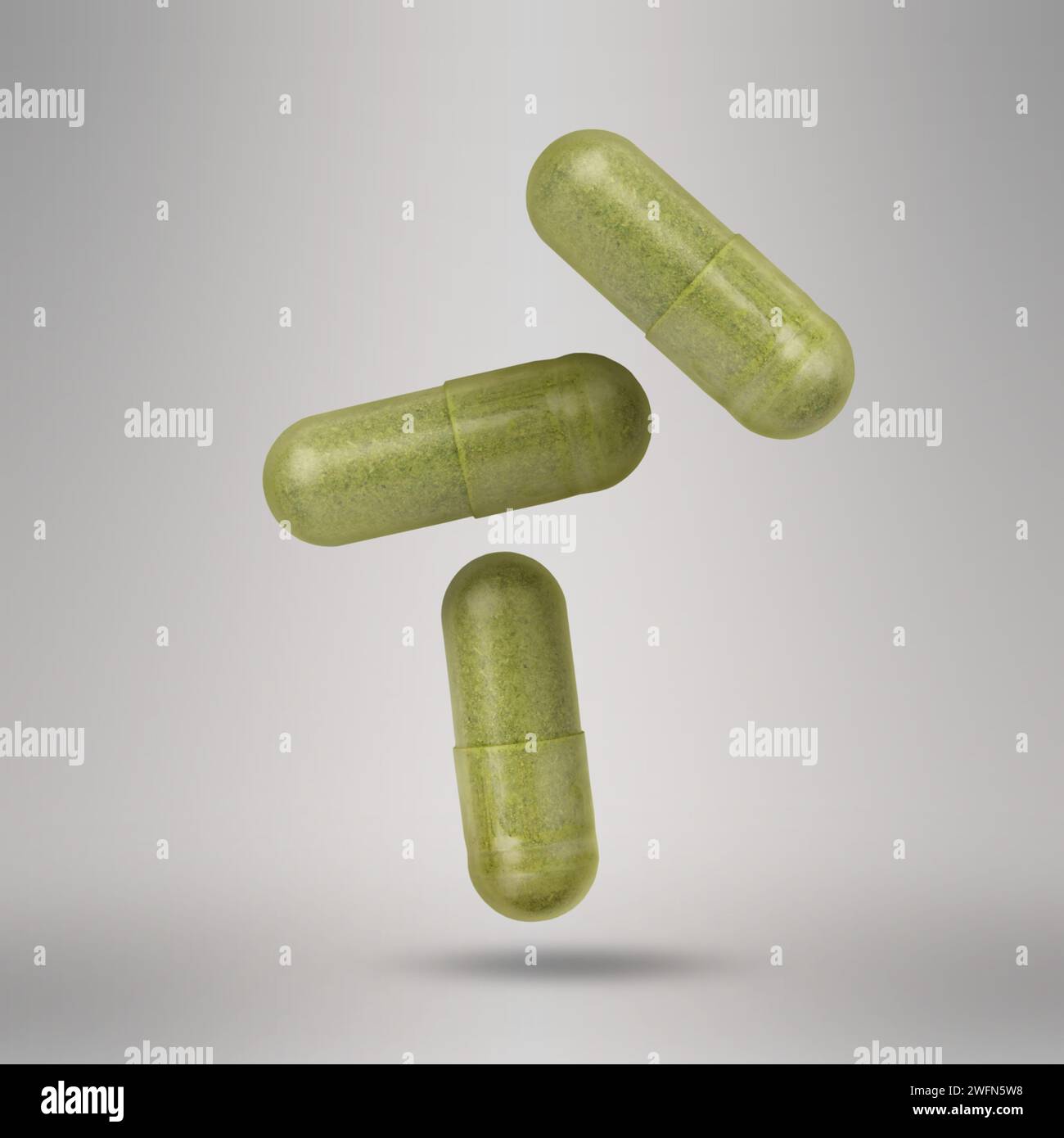 Vitamin. Capsules falling on light grey background Stock Photo - Alamy