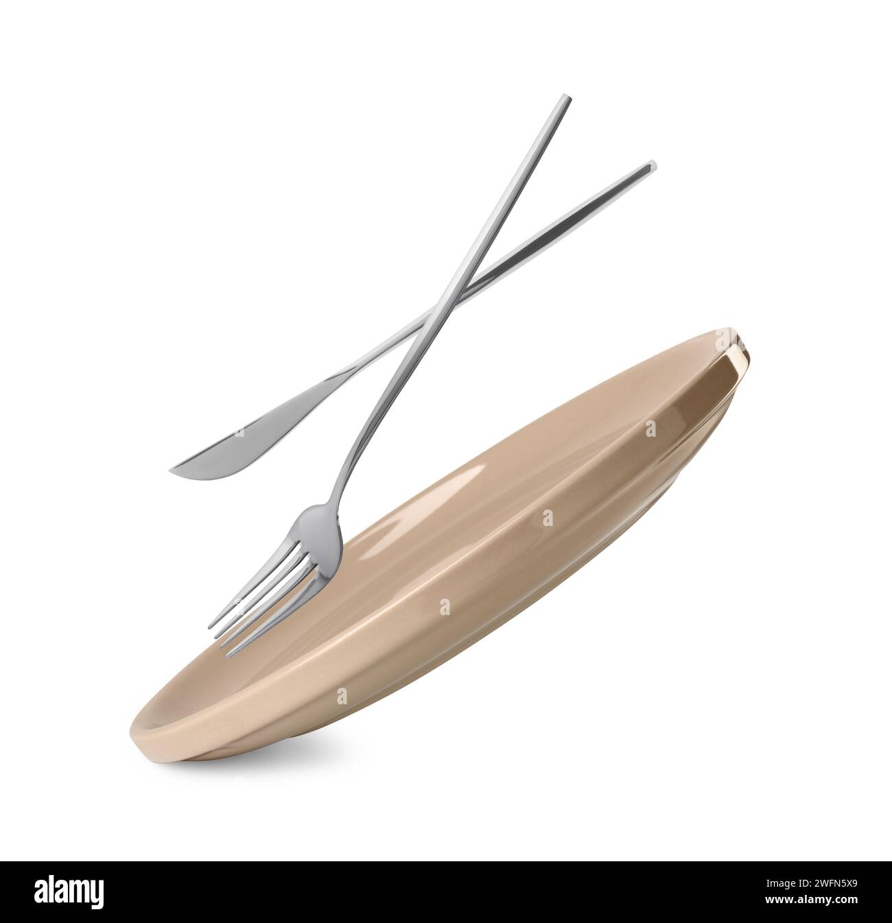 Clean plate, fork and knife falling on white background Stock Photo - Alamy
