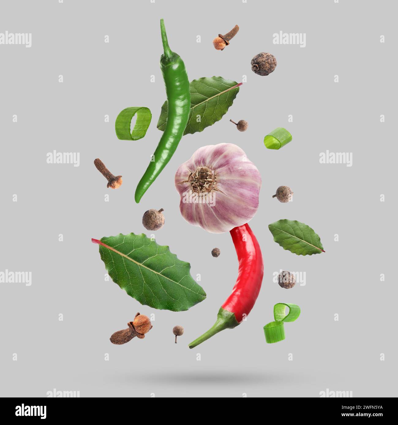 Different spices falling on light grey background Stock Photo - Alamy