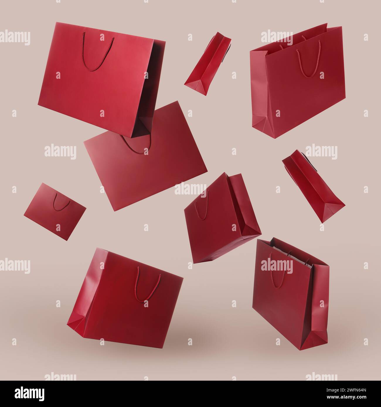 Red shopping bags falling on beige background Stock Photo - Alamy