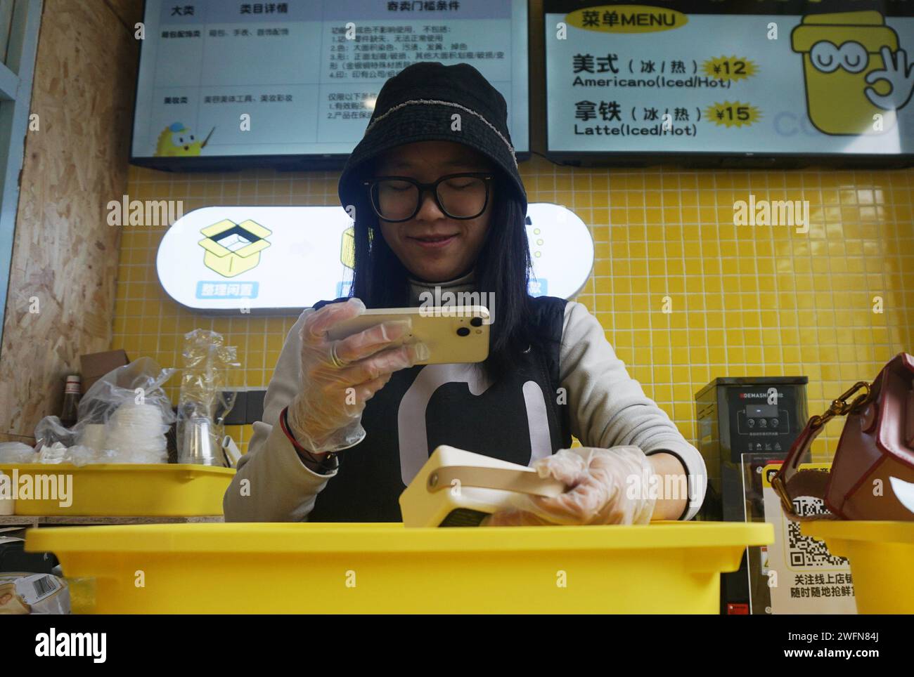 HANGZHOU, CHINA - JANUARY 31, 2024 - A SHOP assistant takes photos of ...