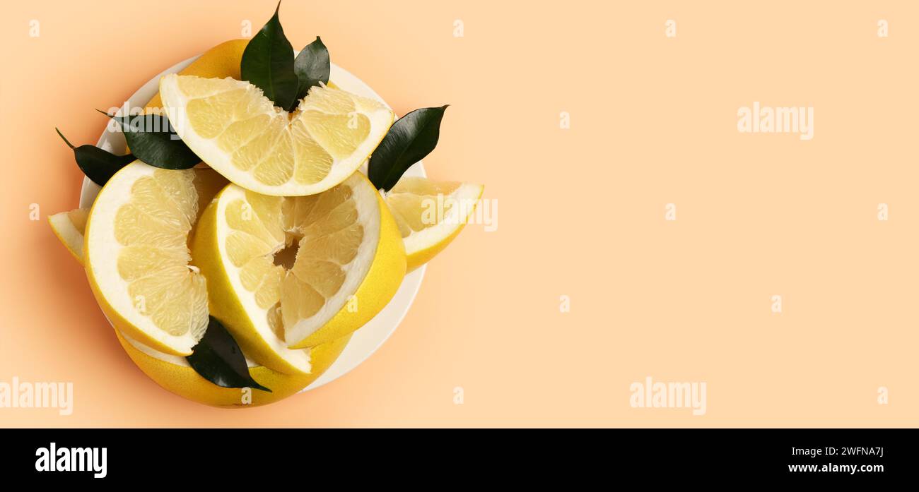 Plate of ripe sliced pomelo on beige background with space for text ...