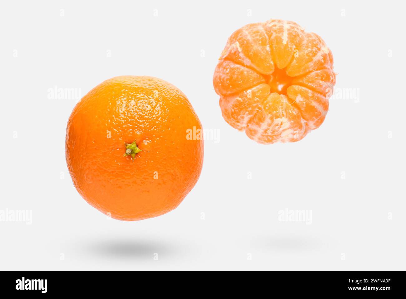 Flying fresh tangerines on white background Stock Photo - Alamy