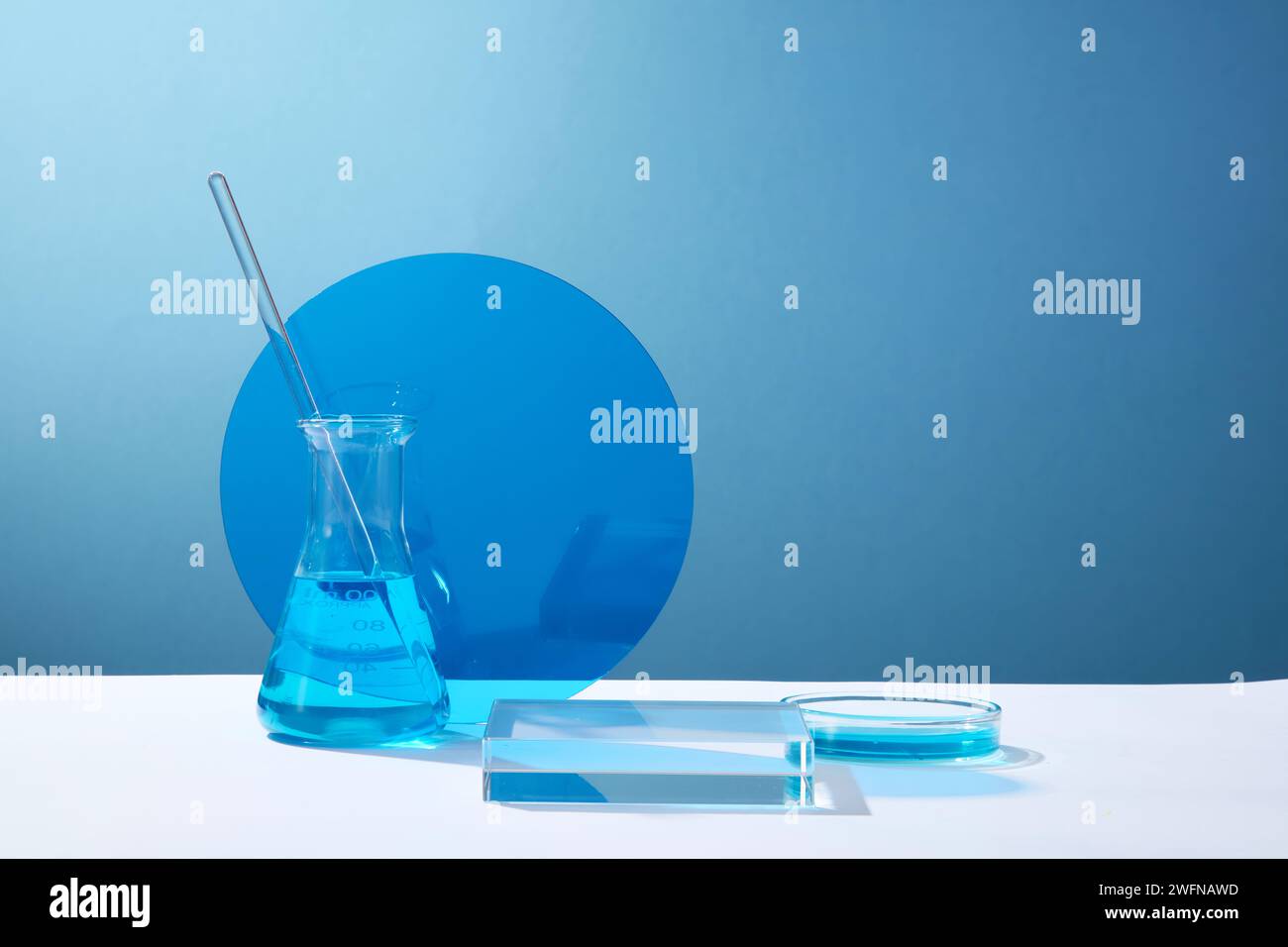 Erlenmeyer flask with glass rod and a glass petri dish containing blue ...