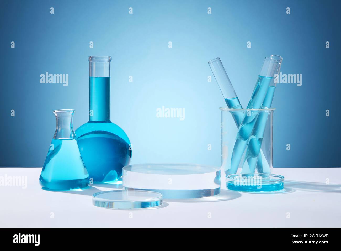 Front view of circle transparent podium and laboratory glassware filled ...