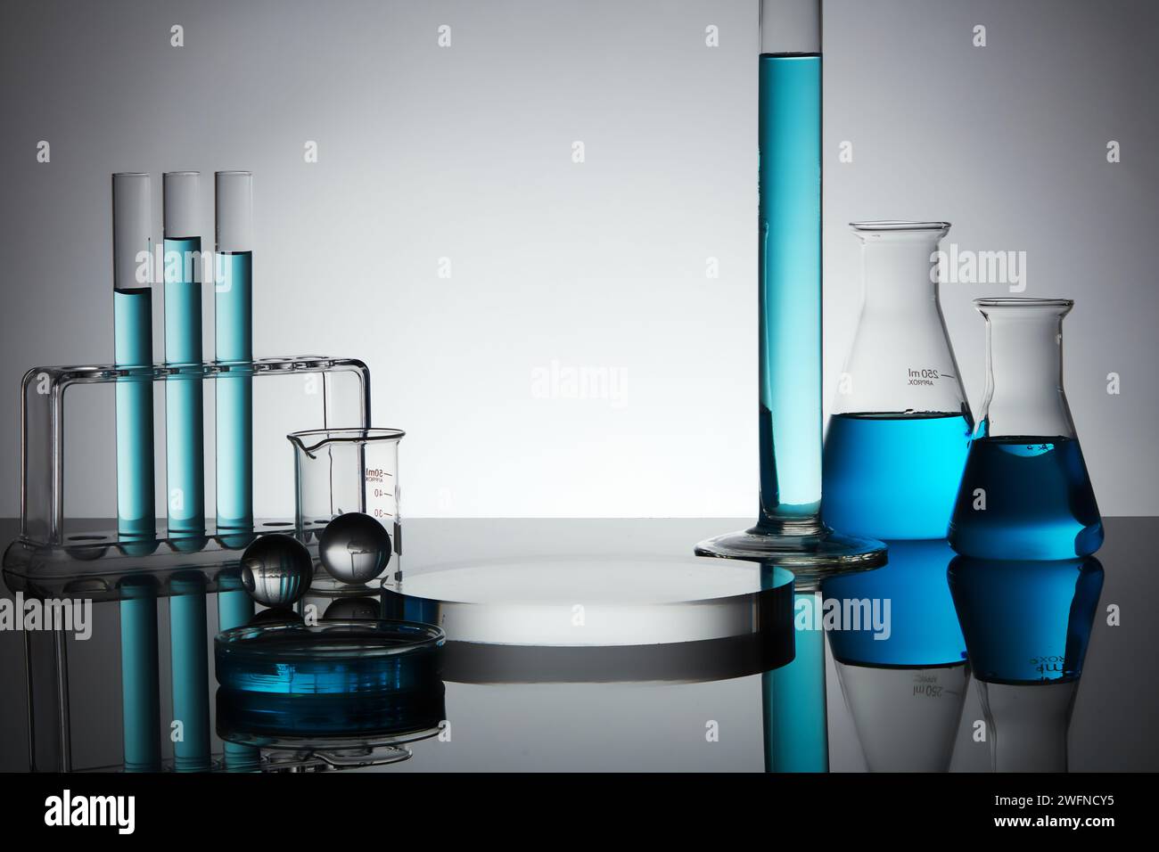 Blue liquid is filled inside petri dish and some laboratory glassware ...