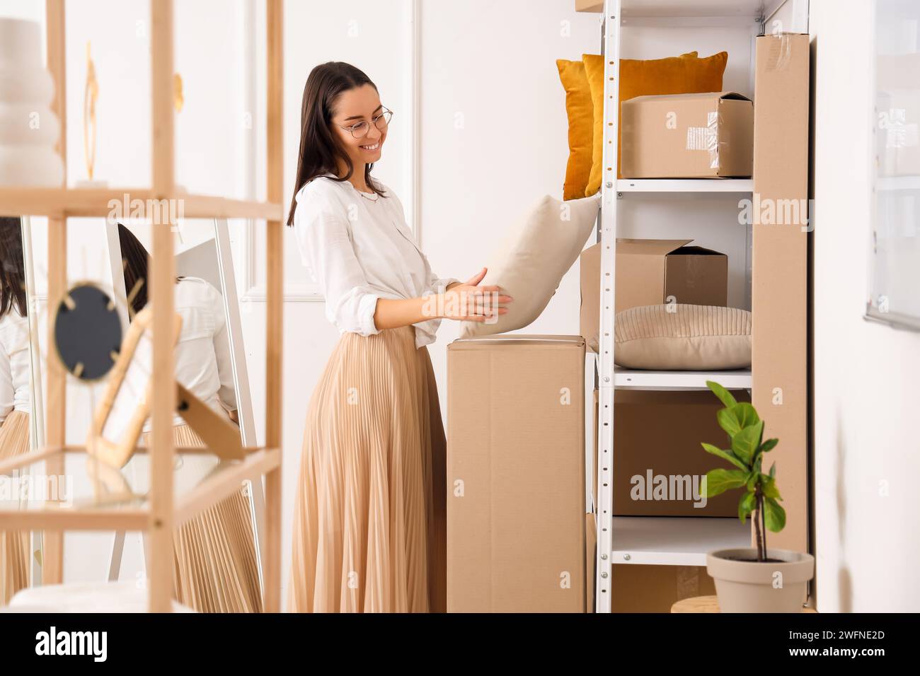 Female seller with cushion in warehouse store Stock Photo - Alamy