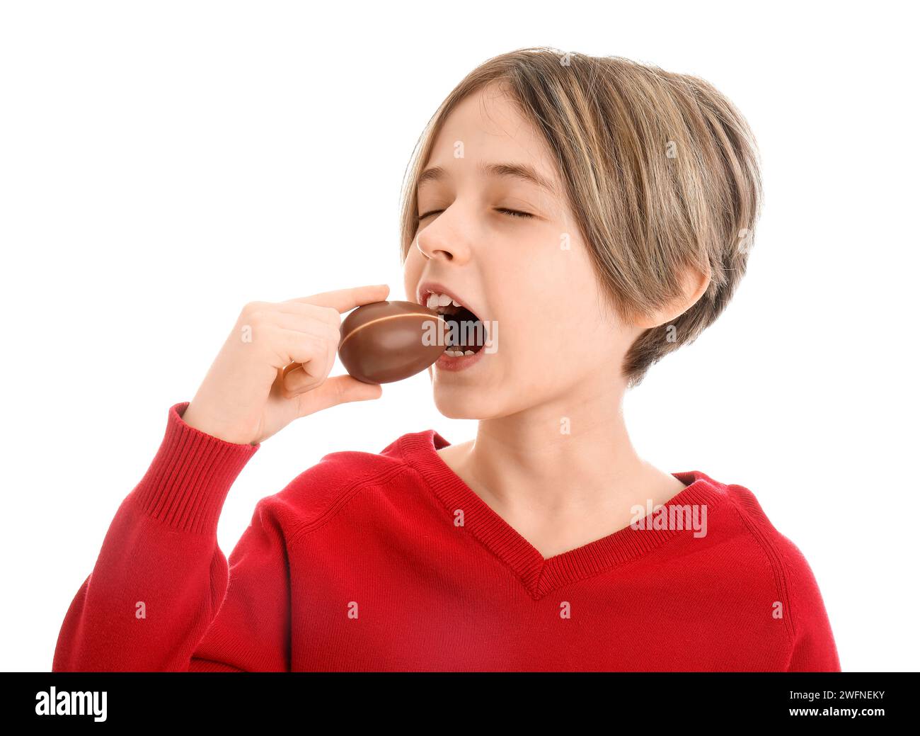 Cute little boy eating chocolate egg on white background. Easter ...