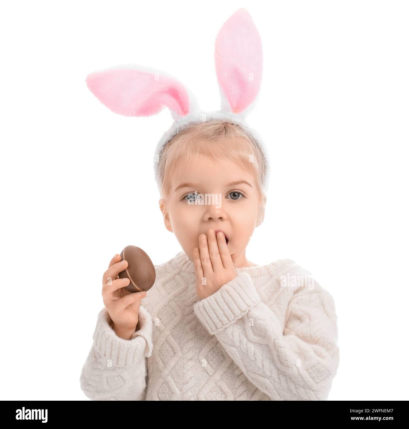 Shocked little girl in bunny ears with chocolate egg on white ...