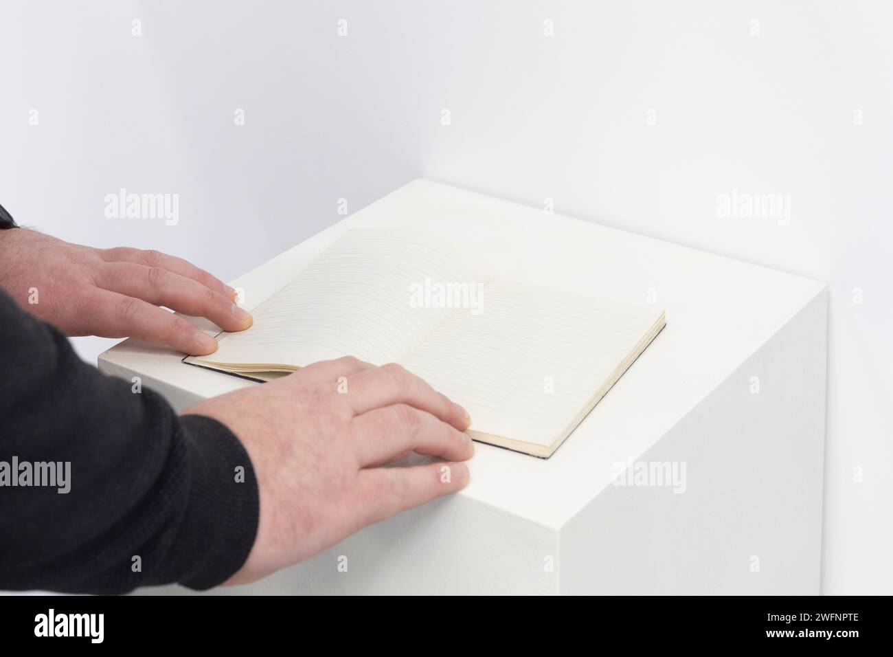 Man opening a notebook on a plain white background, getting ready for ...