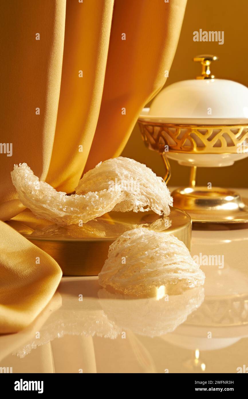 Edible bird nest displayed on golden podium in round shape with yellow ...