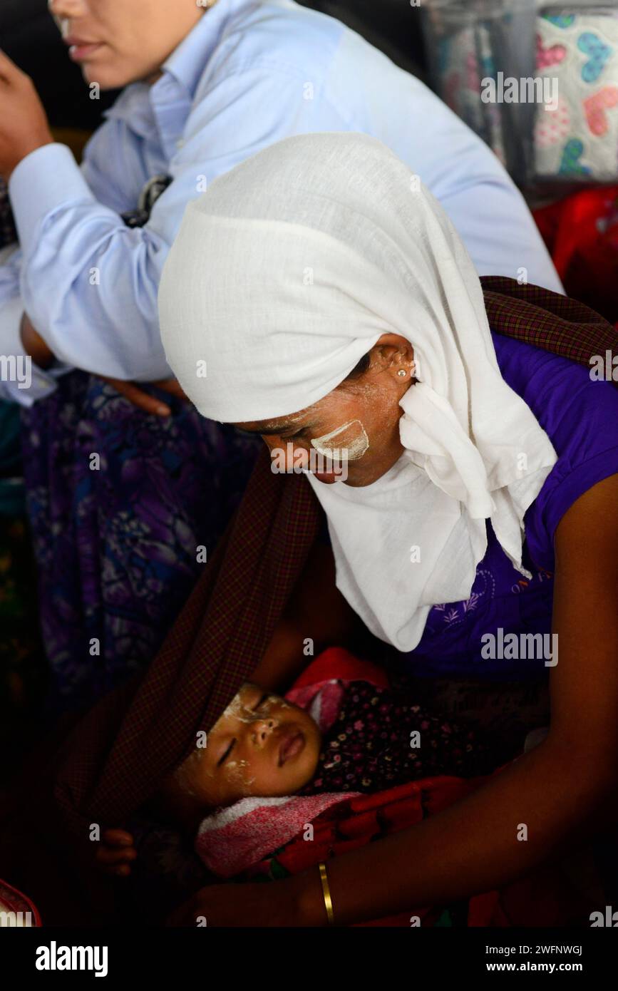 An Arakanese woman breastfeeding her baby on the ferry between Sittwe and Mrauk-U in western ...