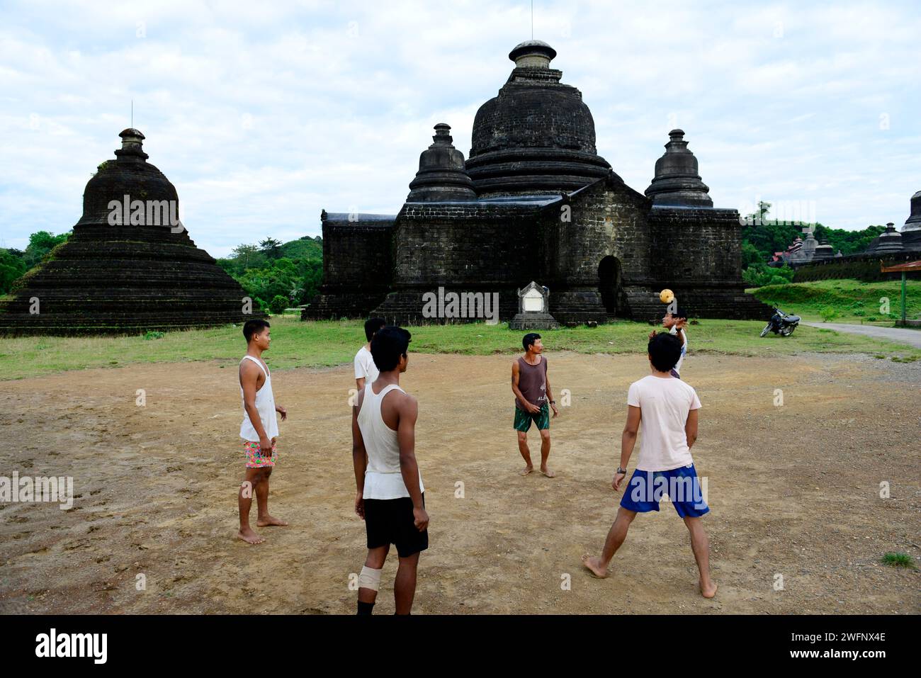 Arakanese men playing football near one of the old templs in Mrauk-U ...