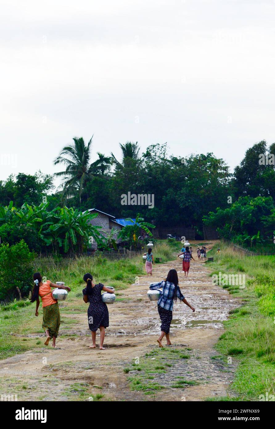Young Arakanese girls carrying water jugs back to their village in ...