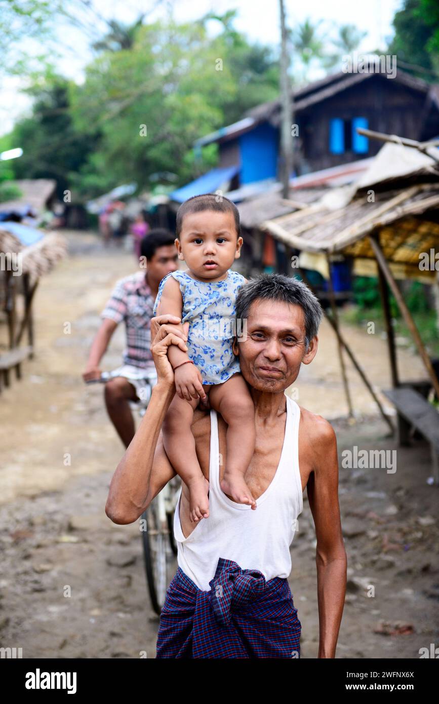 Portrait of an Arakanese man holding his granddaughter in Mrauk-U ...