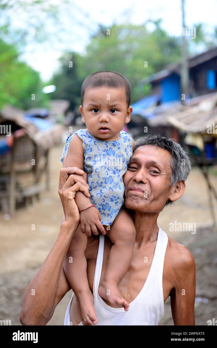 Portrait of an Arakanese man holding his granddaughter in Mrauk-U ...