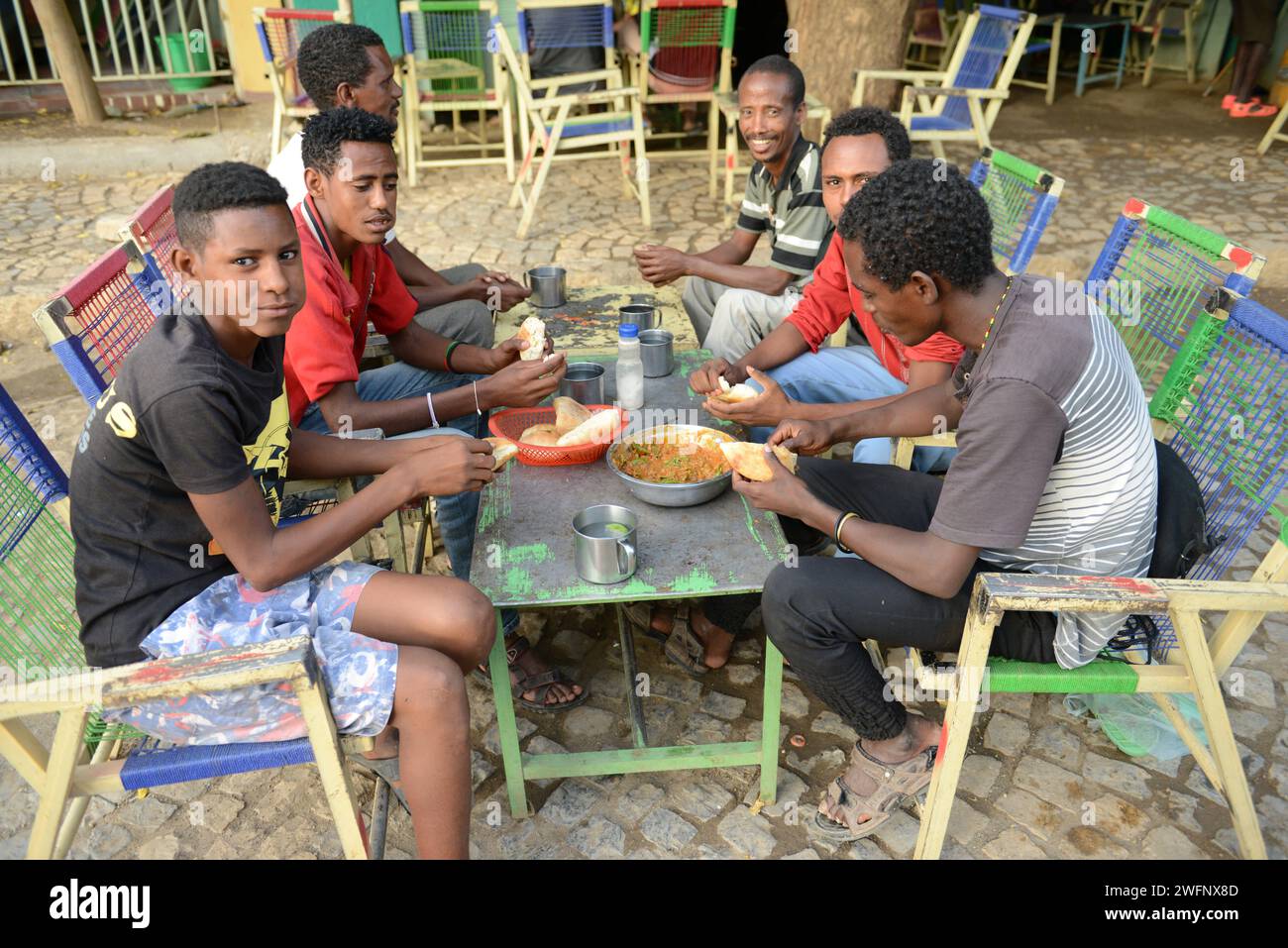Locals enjoying egg & tomato sauce Dabo firfir in a s mall restaurant ...