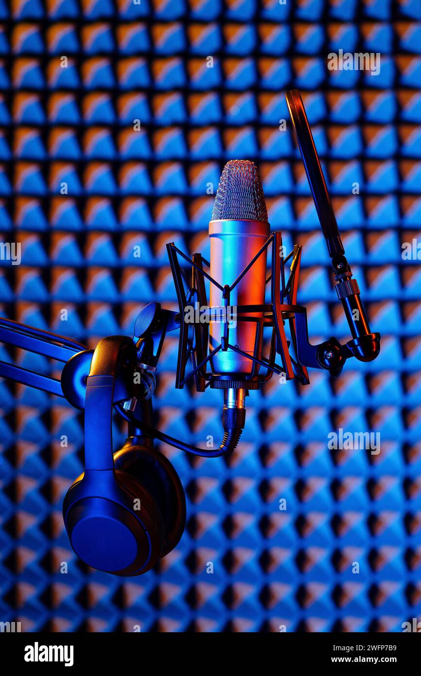 Professional studio microphone against acoustic foam panel background ...