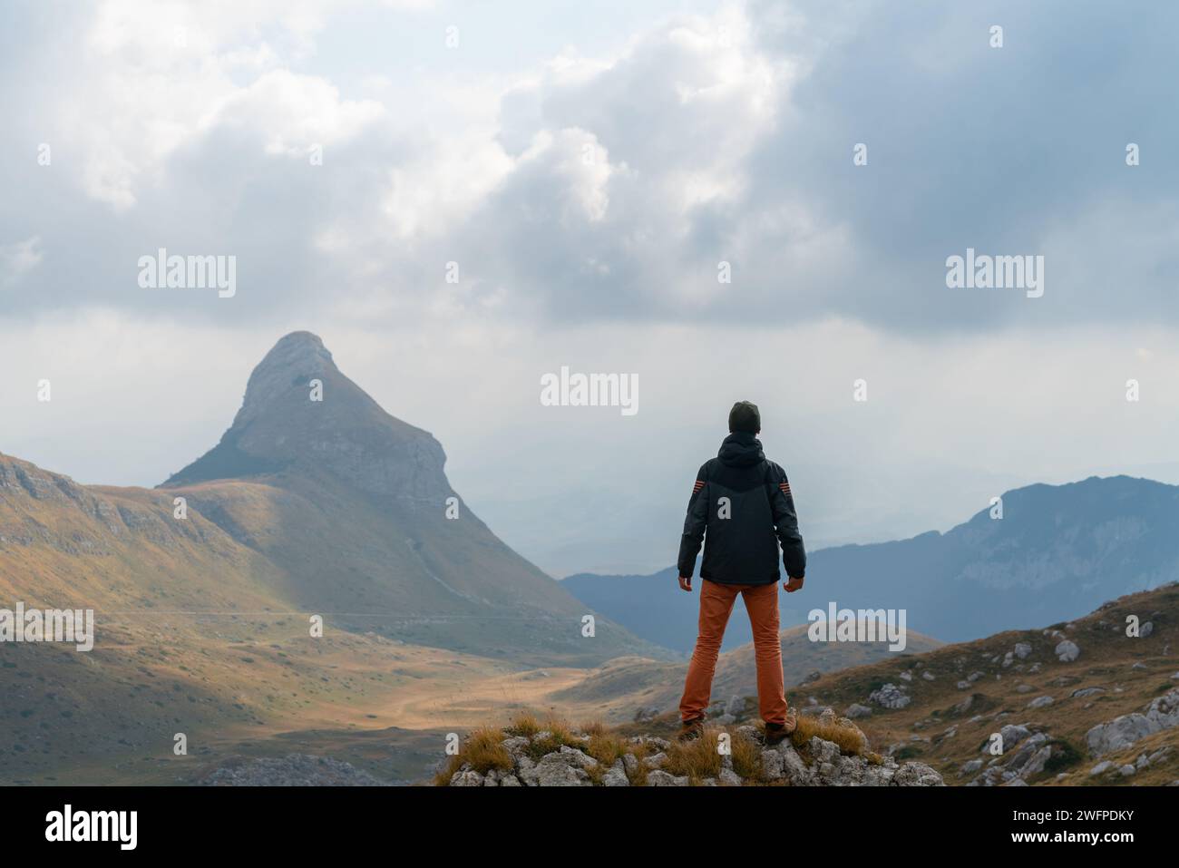Hiker watching to mountains and valley. Spectacular mountain ranges ...