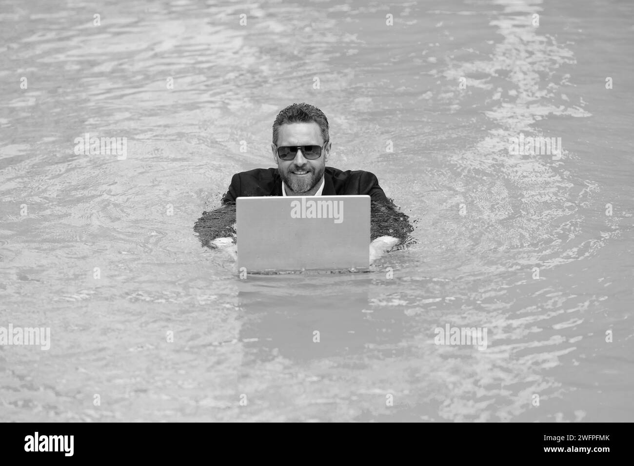 photo of business man working remote swim in summer pool. business man ...