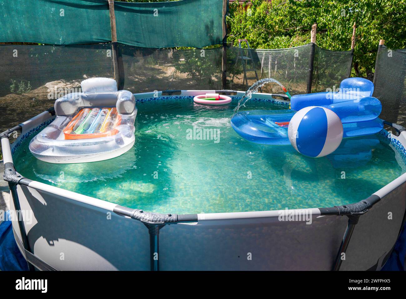 Blue plastic pool in the garden Stock Photo - Alamy