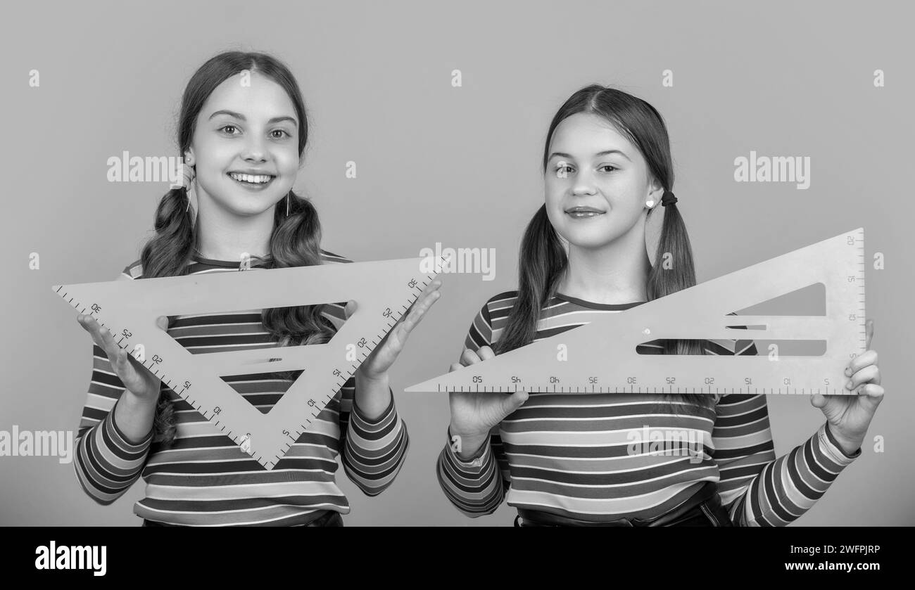 smiling school kids hold math tool of triangle Stock Photo - Alamy