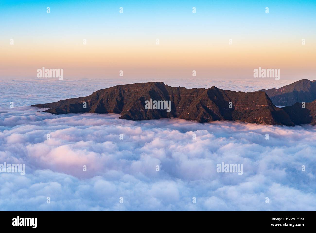 Hills with steep slopes above clouds in Madeira during sunset - view ...
