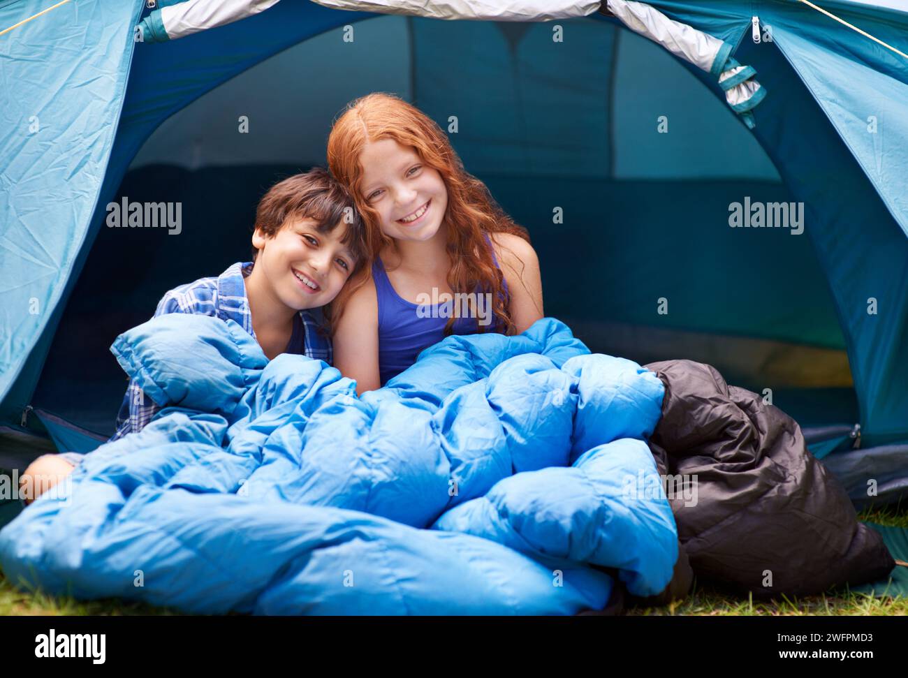 Portrait, camping and children hug in a tent sleeping bag with love ...