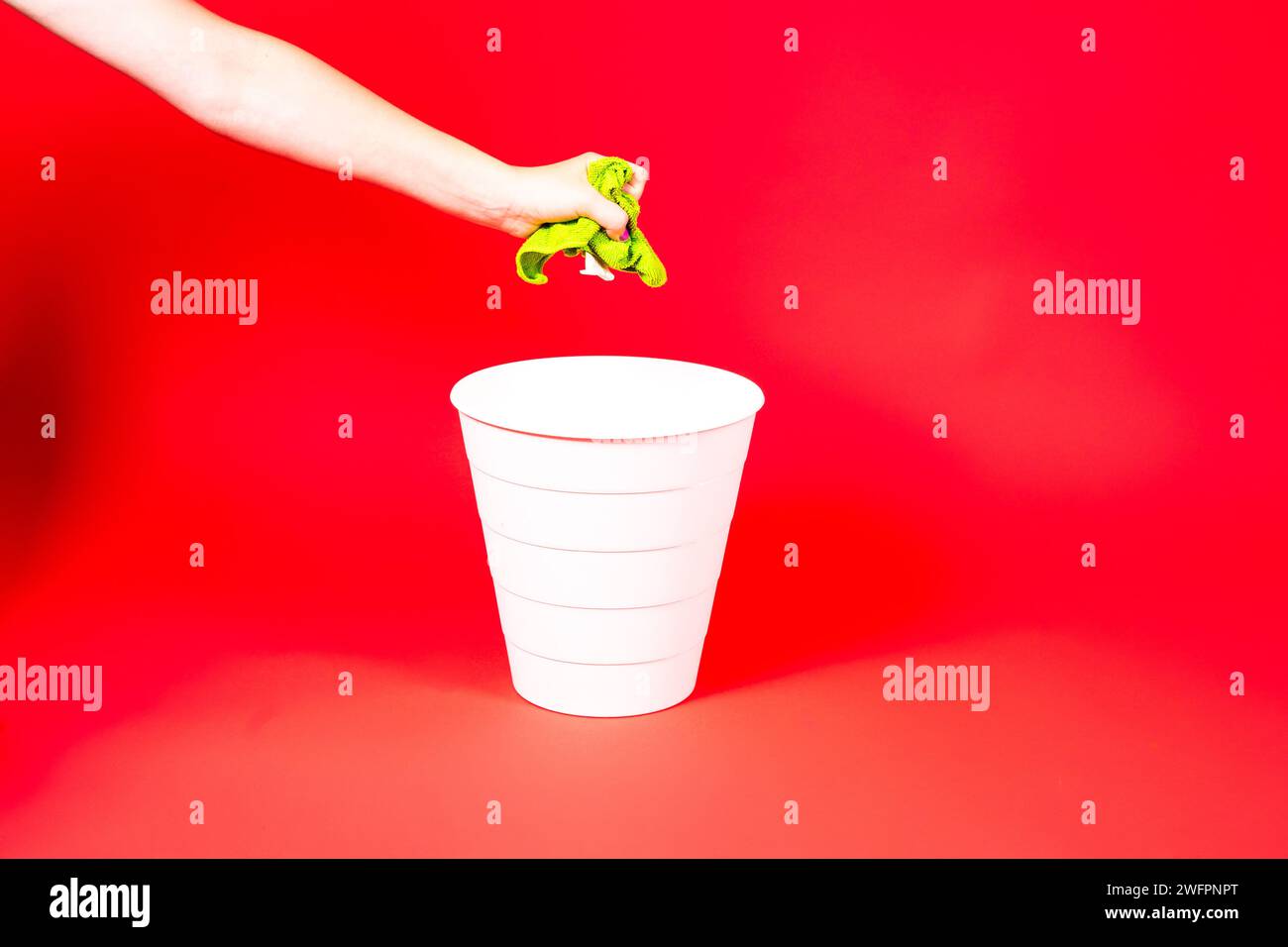 Throw napkin in trash bin, house cleaning rag in hand in front of trash ...