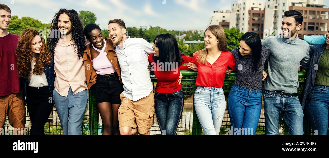 Multiracial young adults share a hearty laugh, bonding in an urban park ...