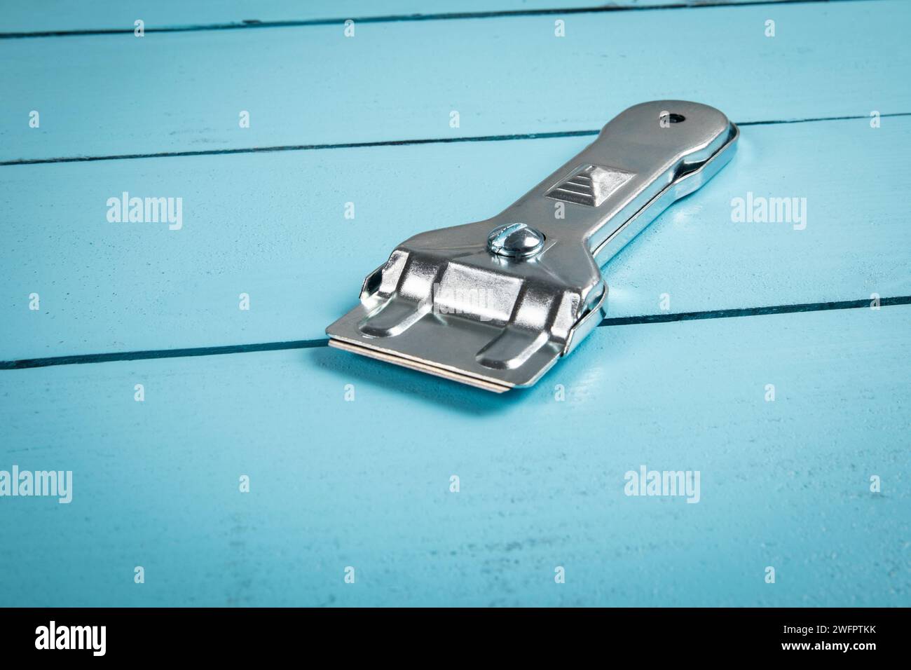 Glass ceramic scraper on a blue wooden texture background Stock Photo ...