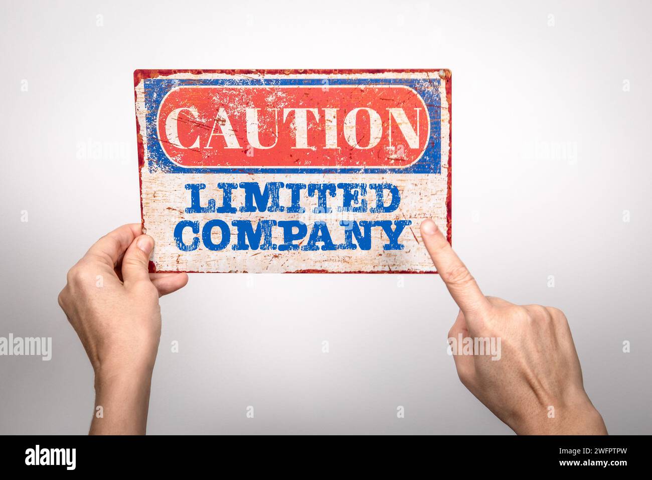 Limited Company. Metal Caution sign in a woman's hand on a white ...