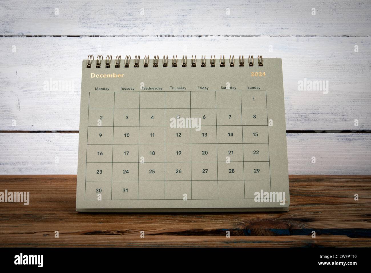 DECEMBER 2024. Cardboard desk calendar and planner on a wooden texture ...