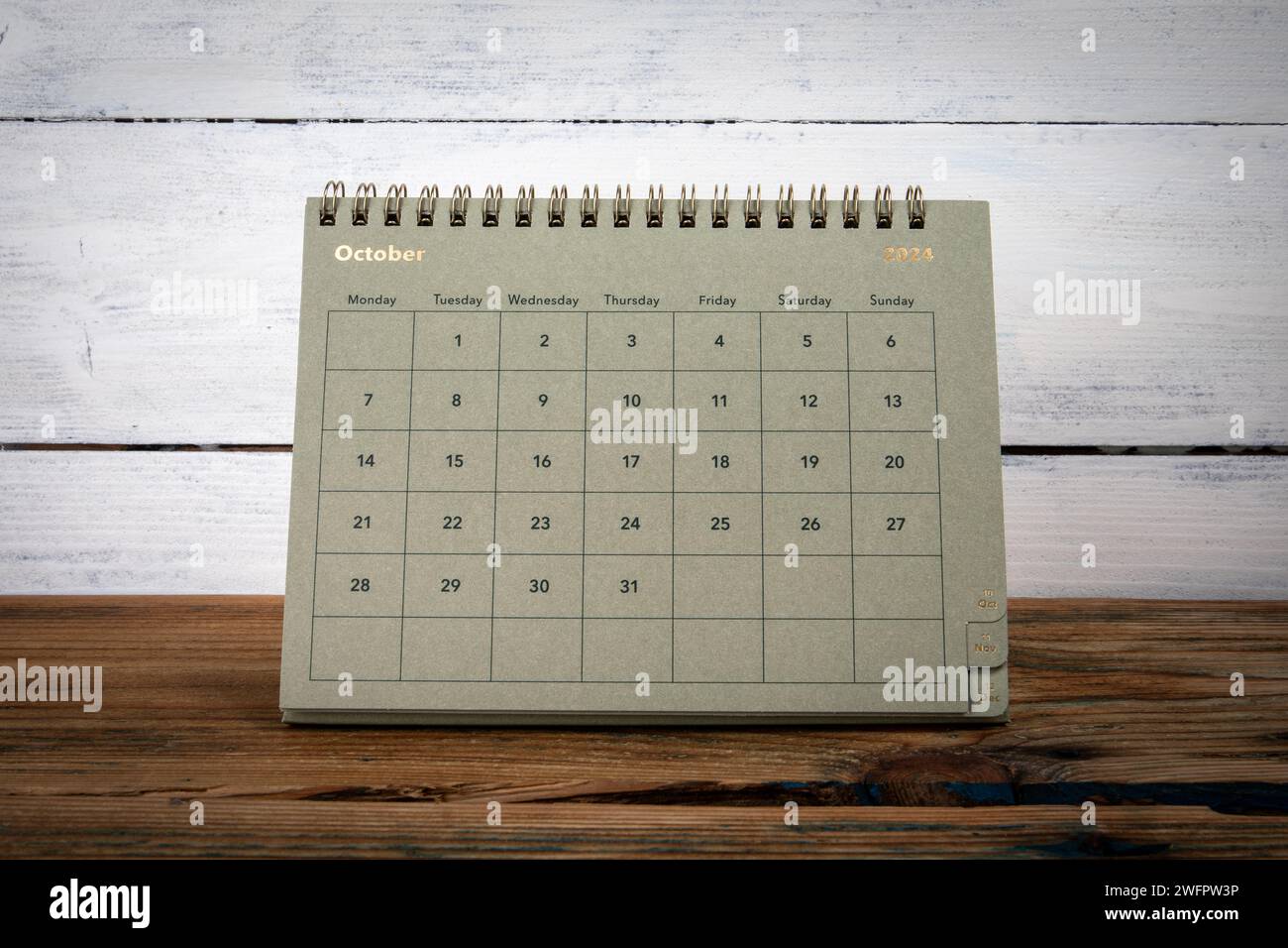 OCTOBER 2024 cardboard desk calendar and planner on a wooden texture ...