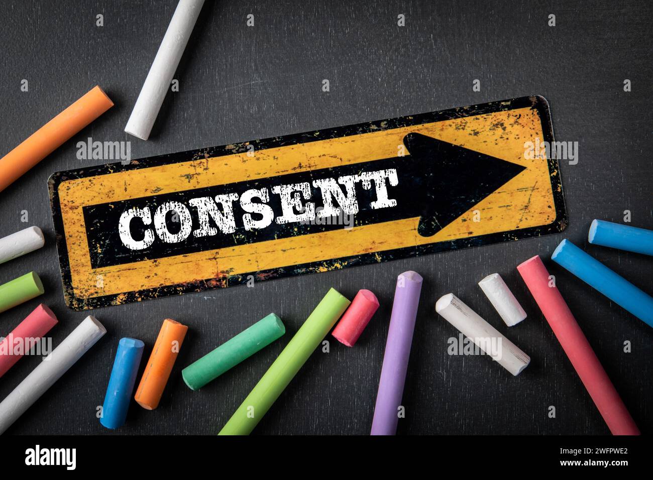 Consent. Direction arrow with text on a dark chalkboard background ...